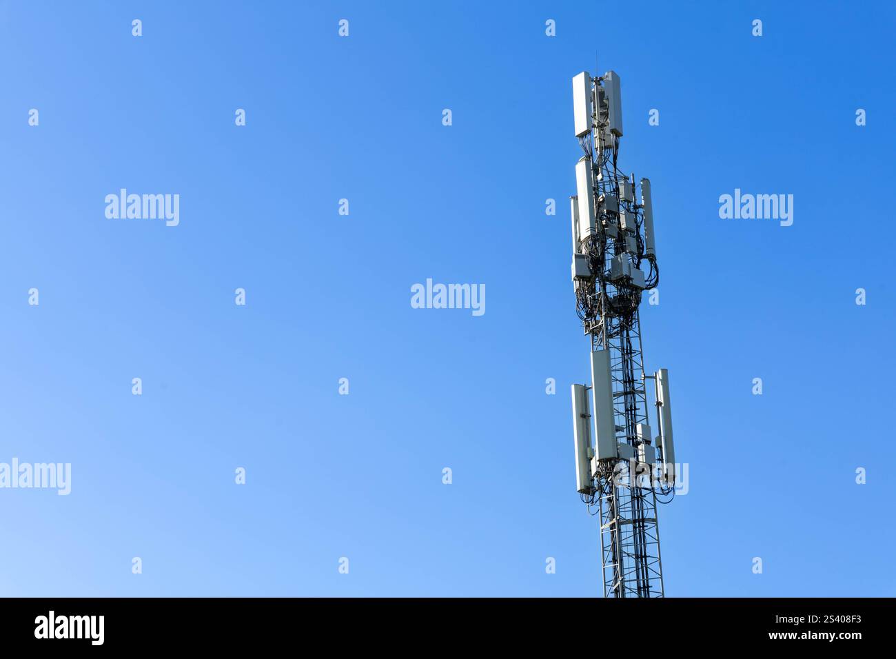 White antennas on cell tower close-up. Mobile data transmission tower with antennas against a ...