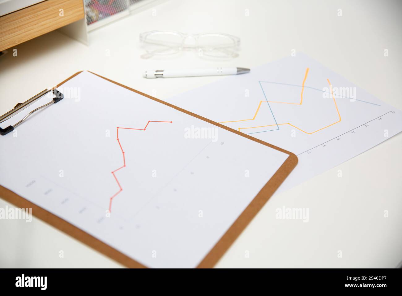 Office workplace table with charts report on wooden clipboard, glasses ...