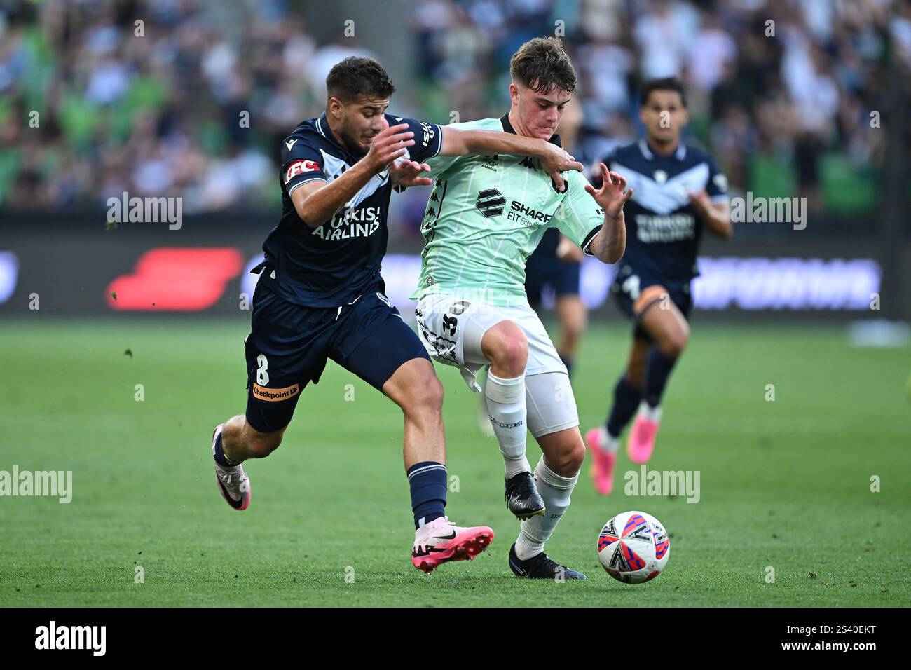 Dylan Leonard of Western United (centre) in action against Zinedine Machach of Melbourne Victory ...