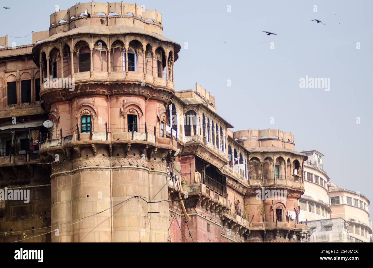 View of historical architecture along the riverbank with colorful boats ...