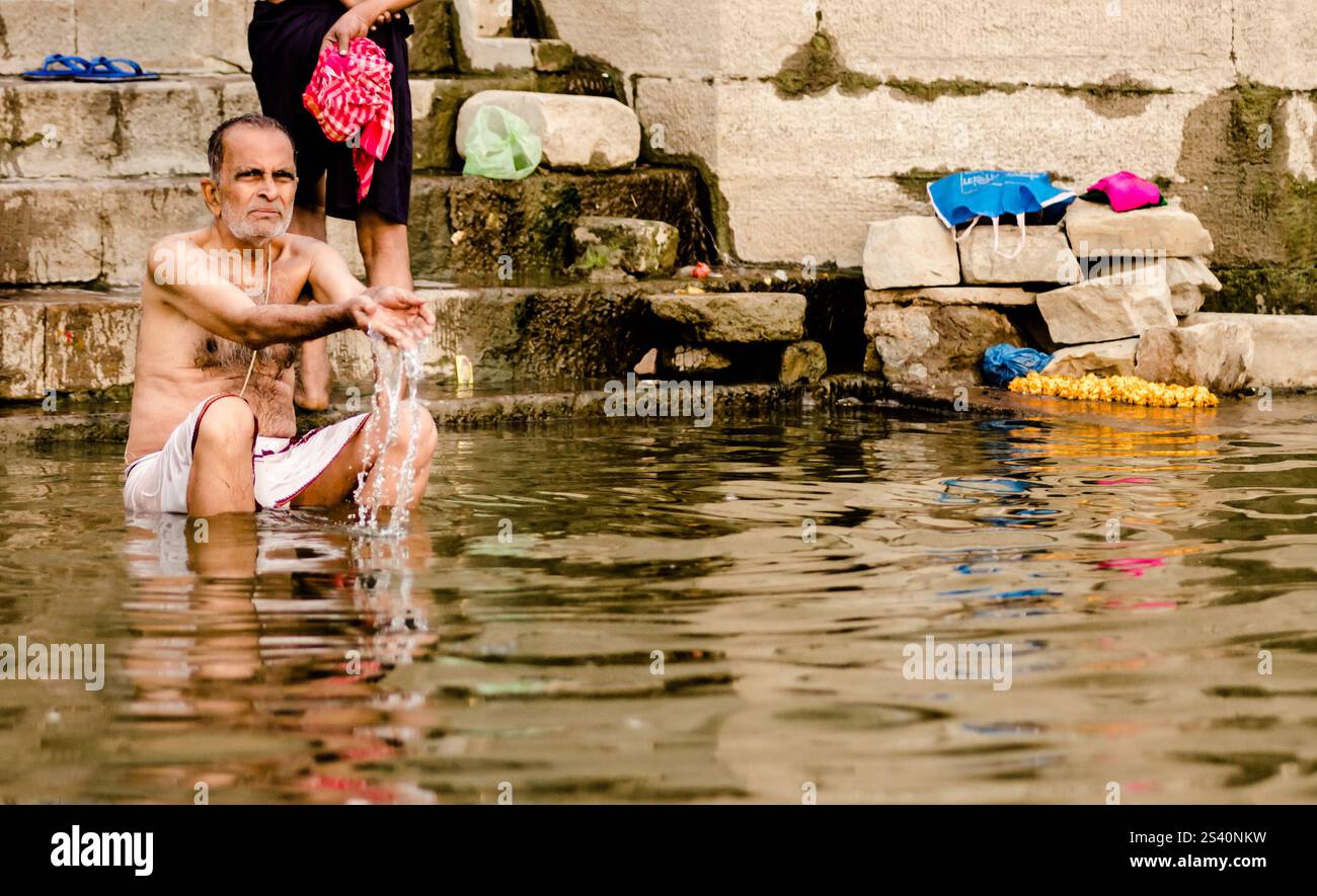 Devotees engage in spiritual cleansing in the Ganges River, surrounded ...