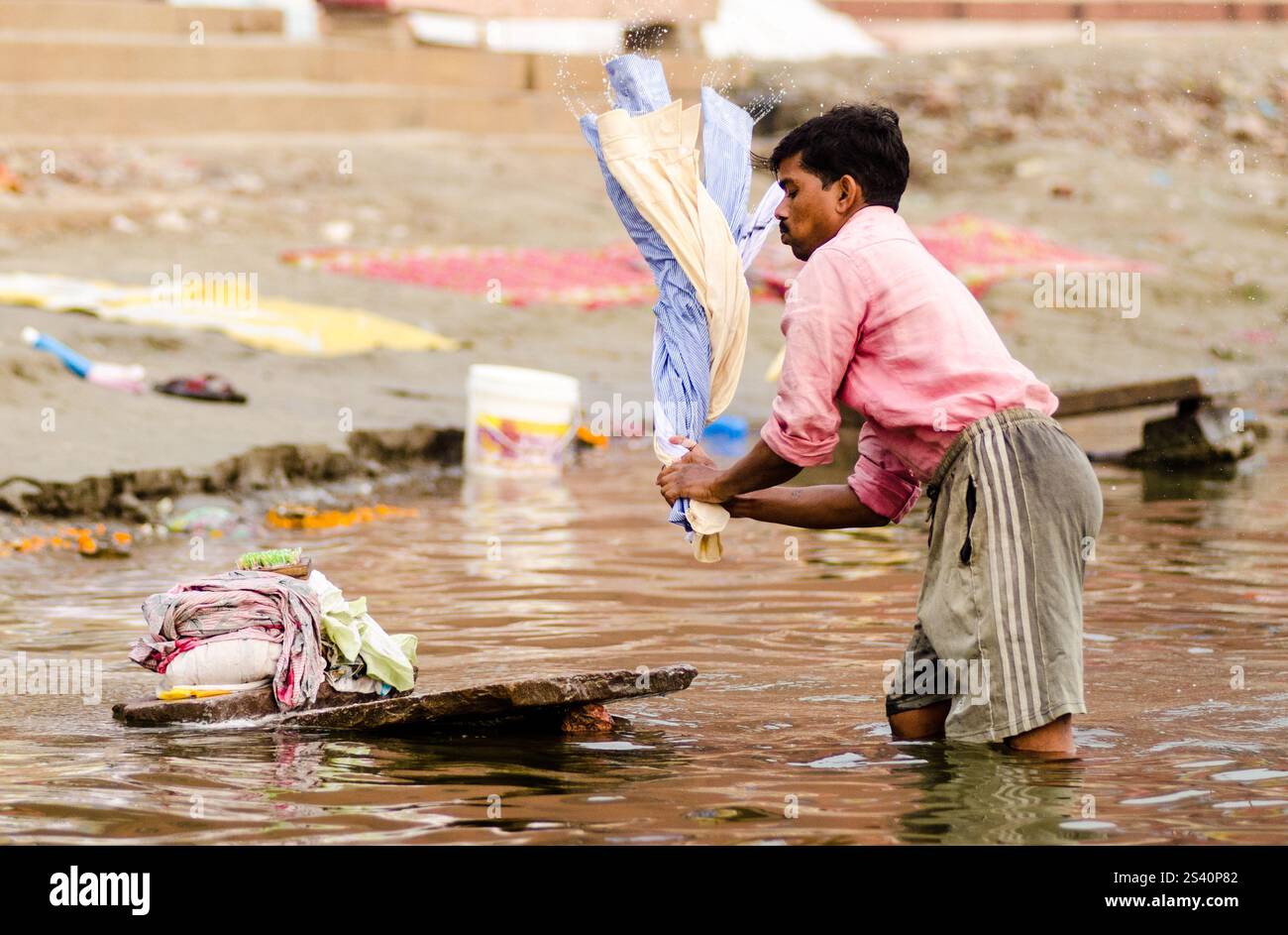 Devotees engage in spiritual cleansing in the Ganges River, surrounded ...