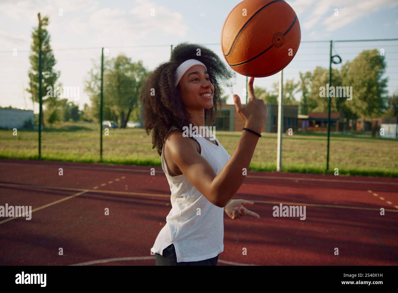 Attractive basketball player spinning ball on finger showing trick ...
