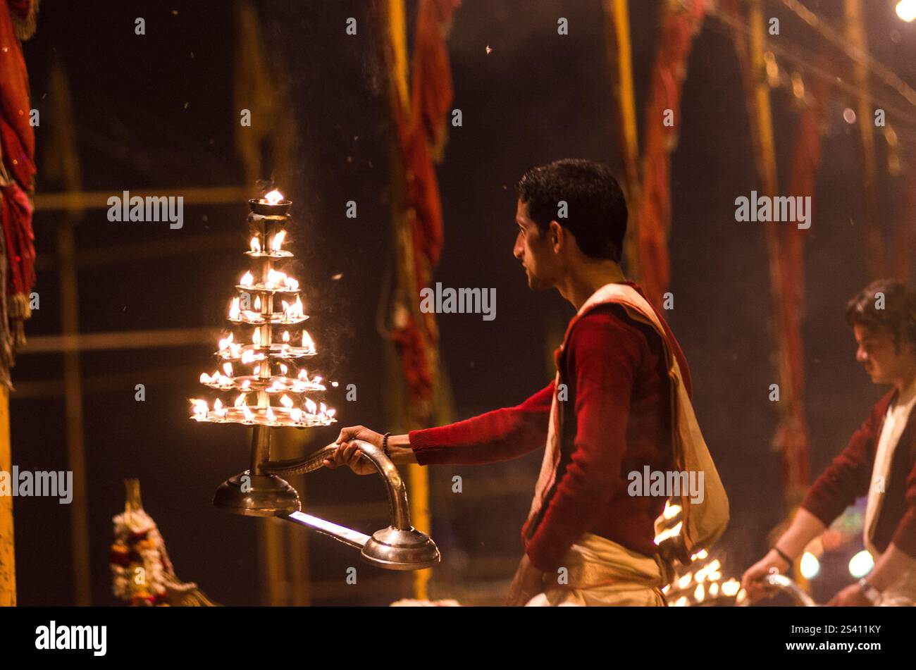Ritual ceremony at night with performers holding lamps and creating ...
