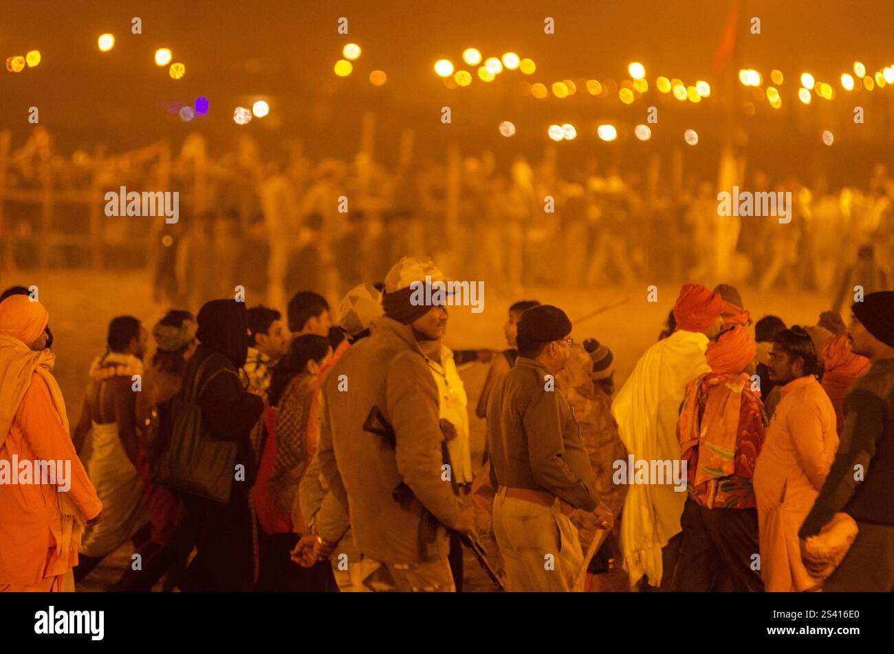 Crowd celebrating cultural festival at night with vibrant lights and ...