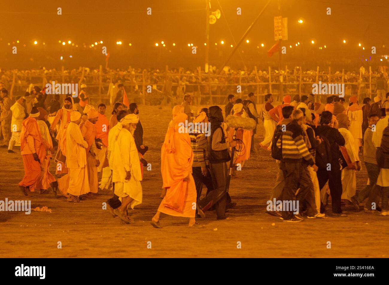 Crowd celebrating cultural festival at night with vibrant lights and ...