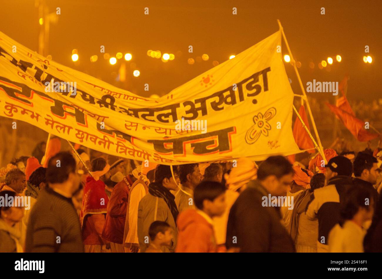 Crowd celebrating cultural festival at night with vibrant lights and ...