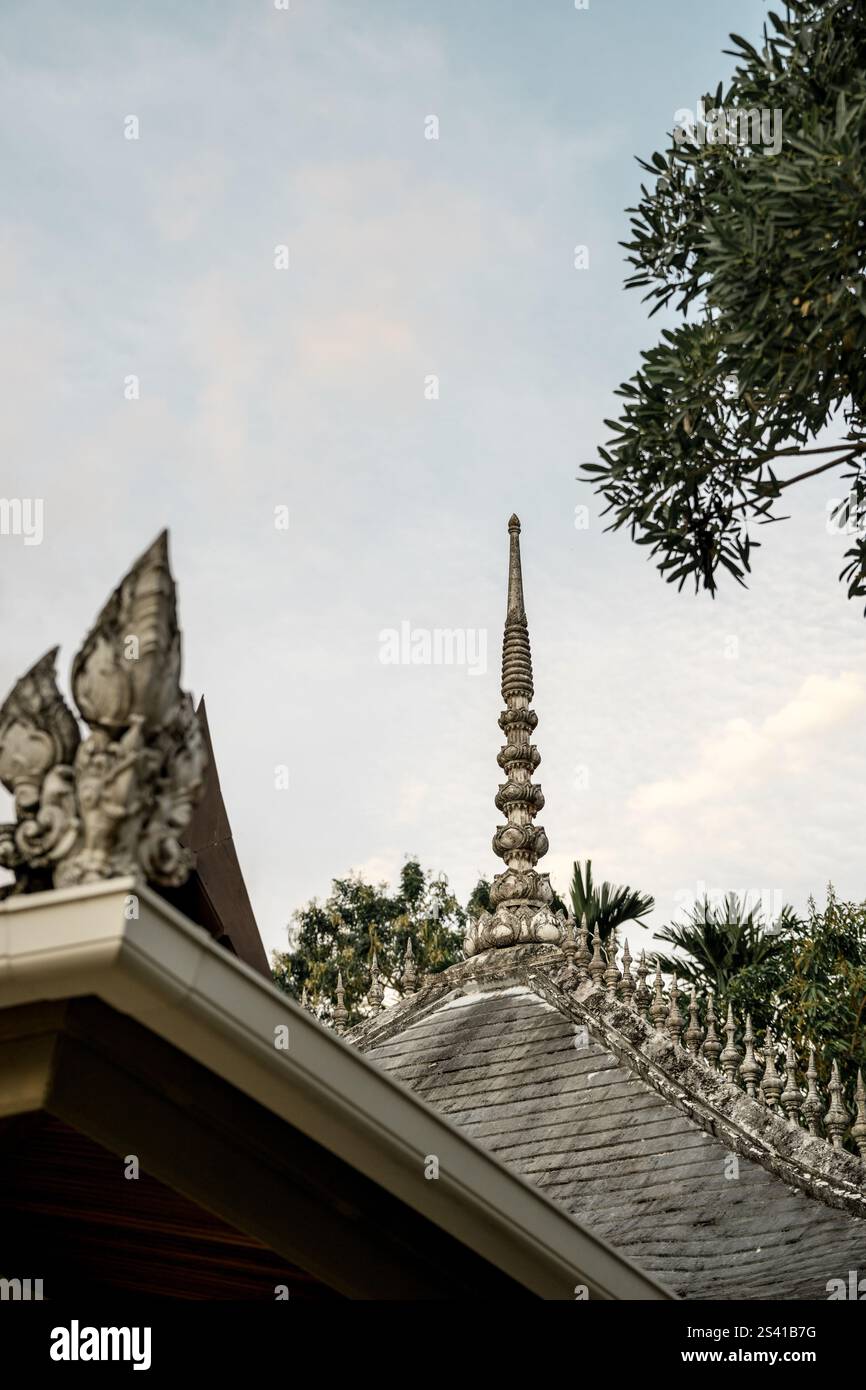 Traditional Thai roof with intricate spire against blue sky Stock Photo ...