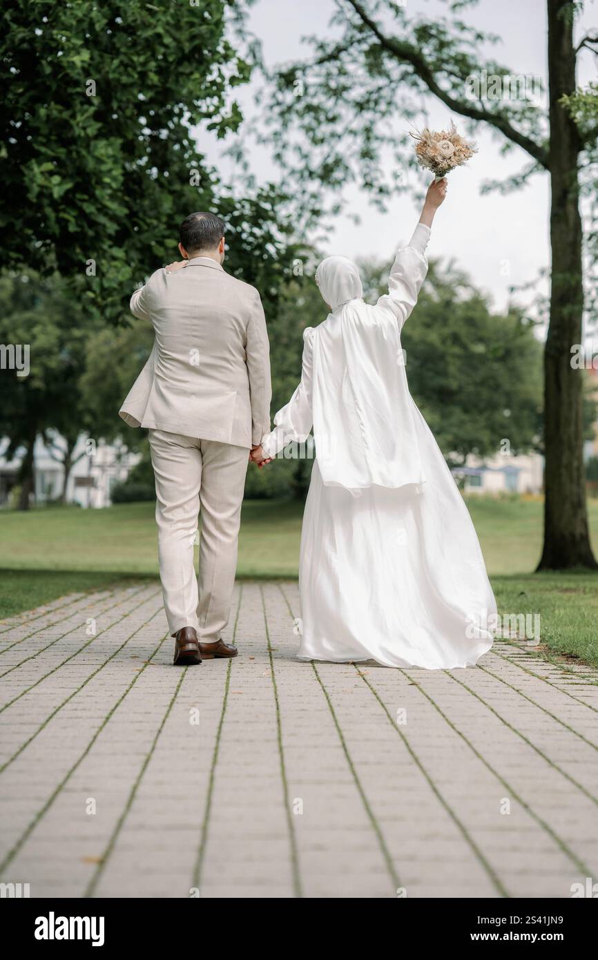 Turkish wedding bride and groom walking down the road in beige clothes ...