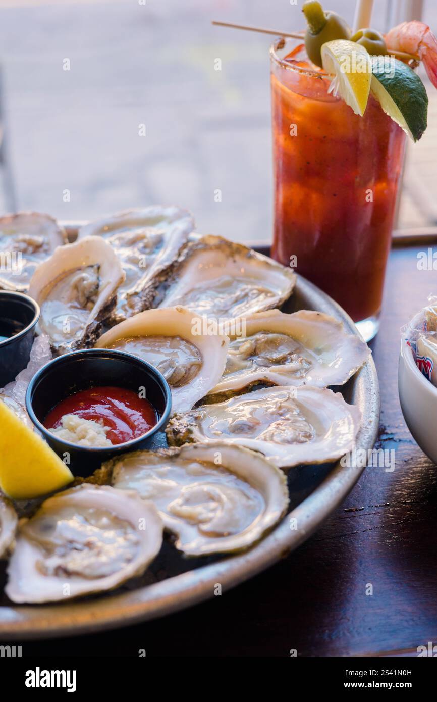 Fresh raw oysters on ice with lemon and a loaded Bloody Mary Stock ...
