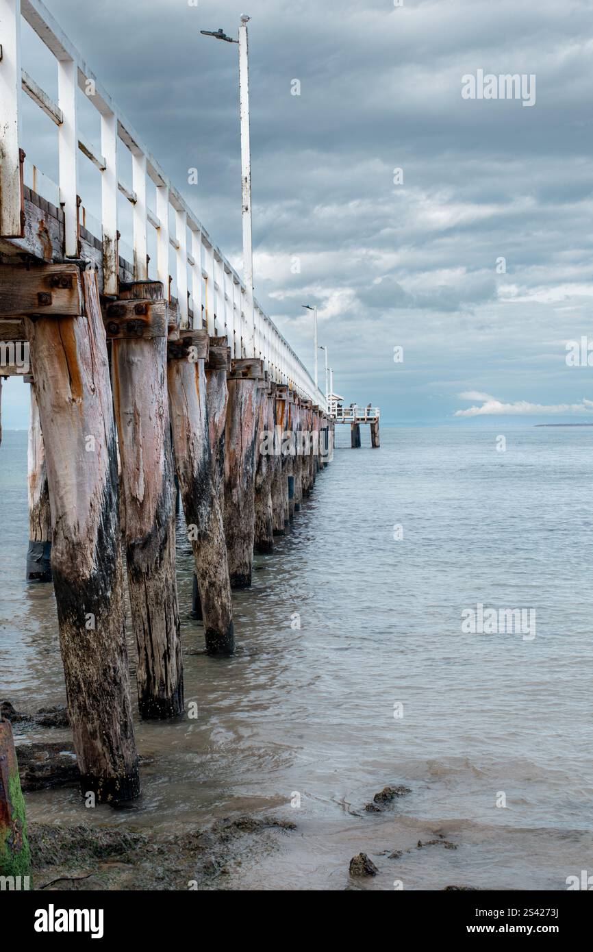 Stormy ocean with pier's weathered wooden posts at Point Lonsdale Pier ...
