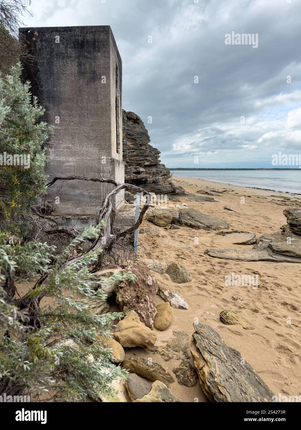 Weathered concrete structure on rocky and sandy beach Point Lonsdale ...