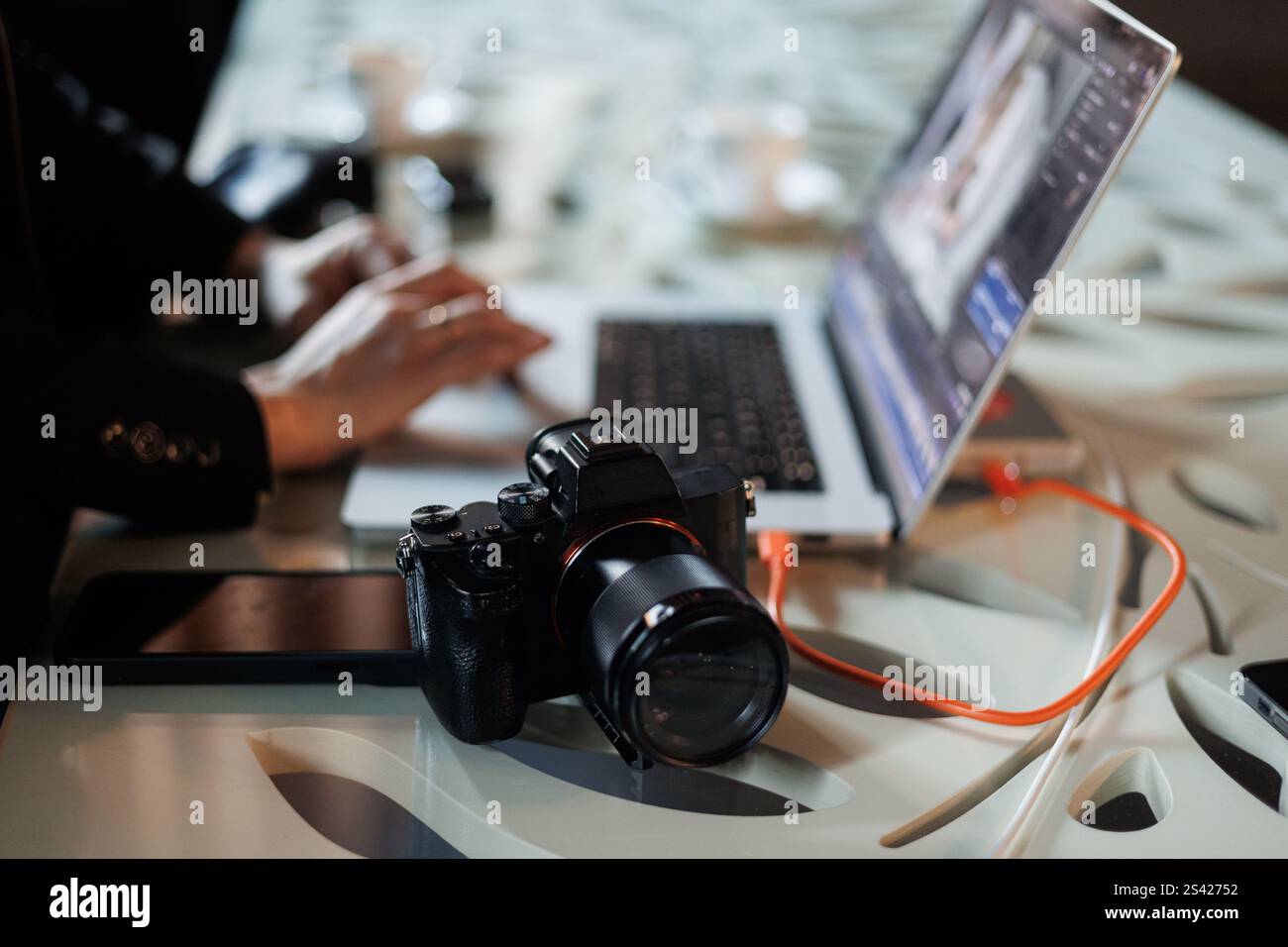 Workspace with laptop and photo camera. Unrecognisable female ...