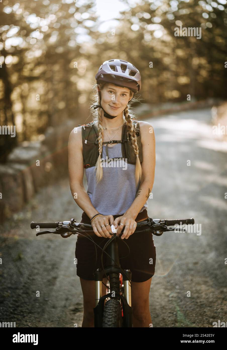 Beautiful female mountain biker smiles while posing for portrait Stock ...