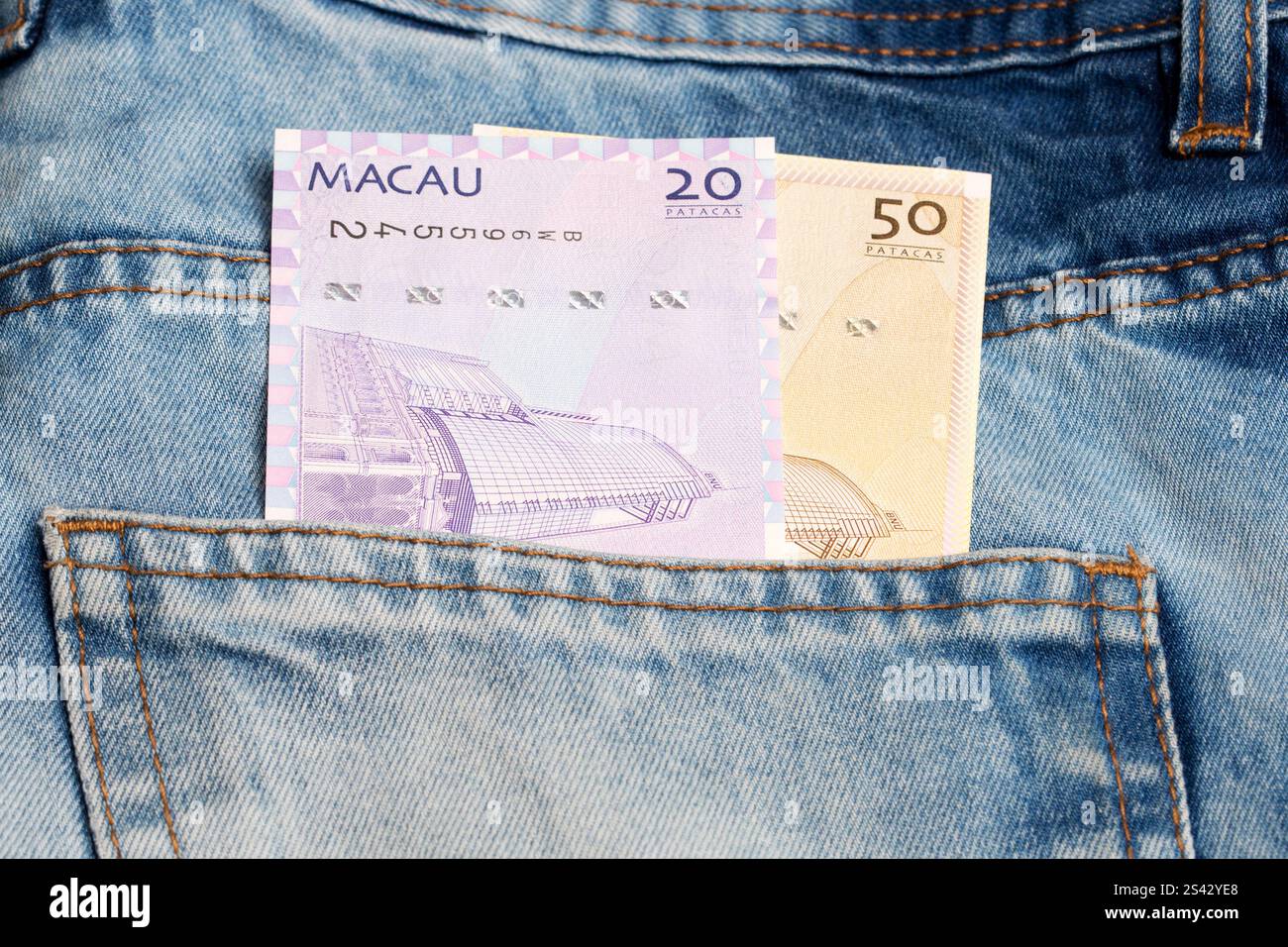 Macanese money - pataca in the pocket of blue jeans Stock Photo - Alamy
