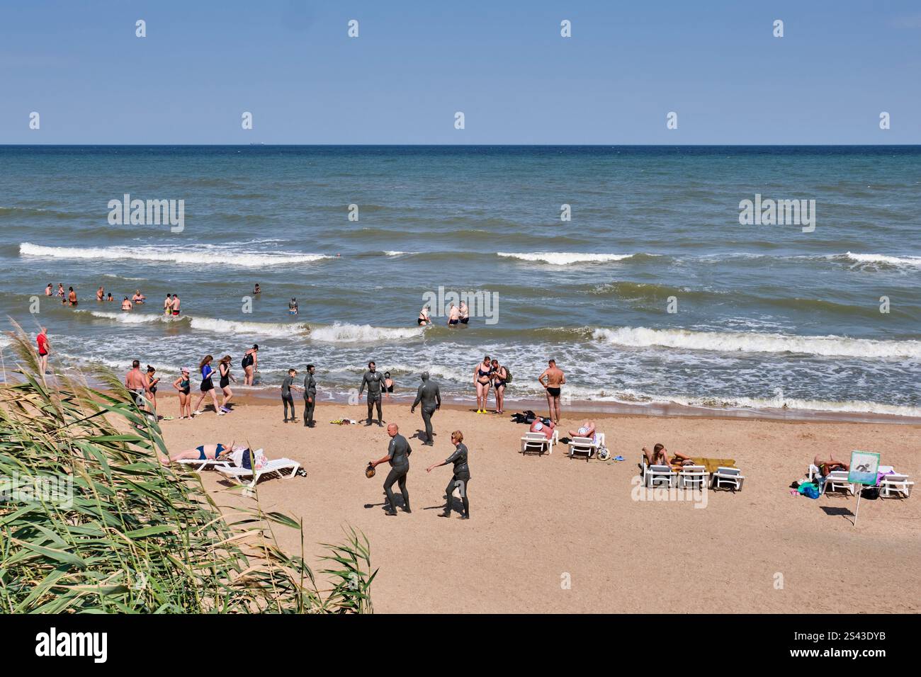 Azov Sea beach scene with people enjoying sunbathing, swimming, mud ...