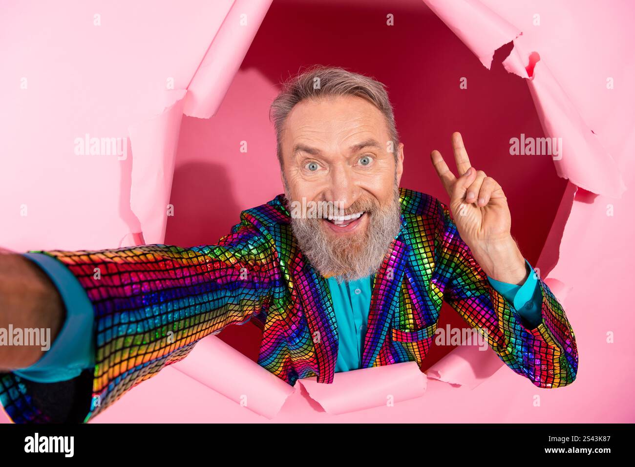 Eccentric senior man in colorful outfit posing against torn pink background Stock Photo - Alamy