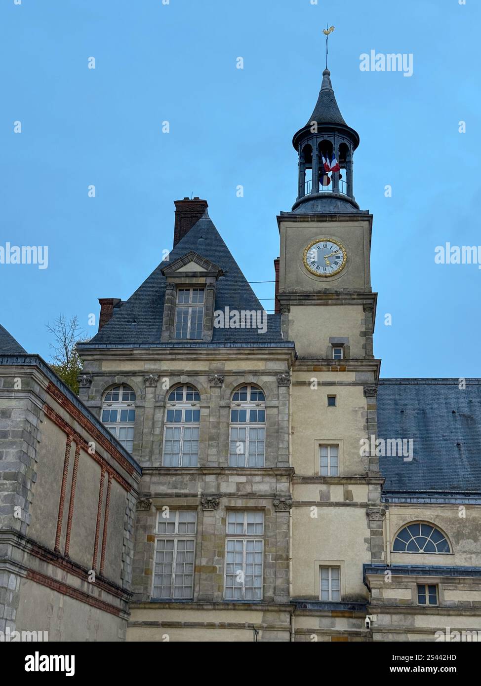 Historic clock tower building under a clear blue sky in a quiet town ...