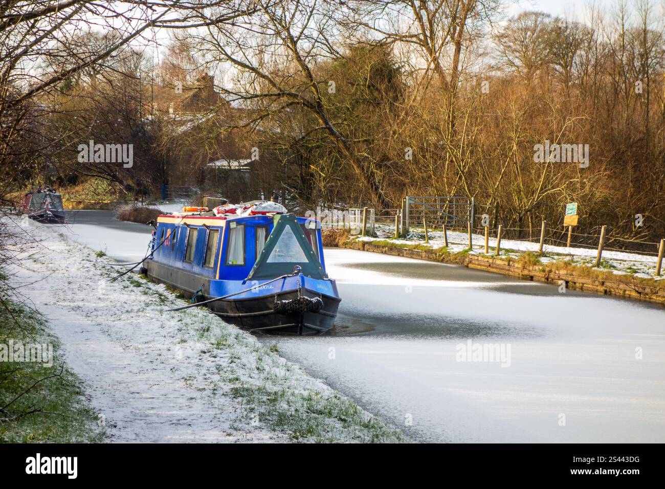Canal narrowboat frozen in an iced up snow covered winter landscape of ...