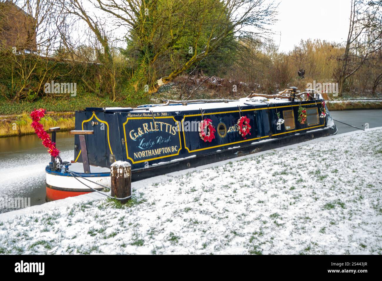 Canal narrowboat frozen in an iced up snow covered winter landscape of ...