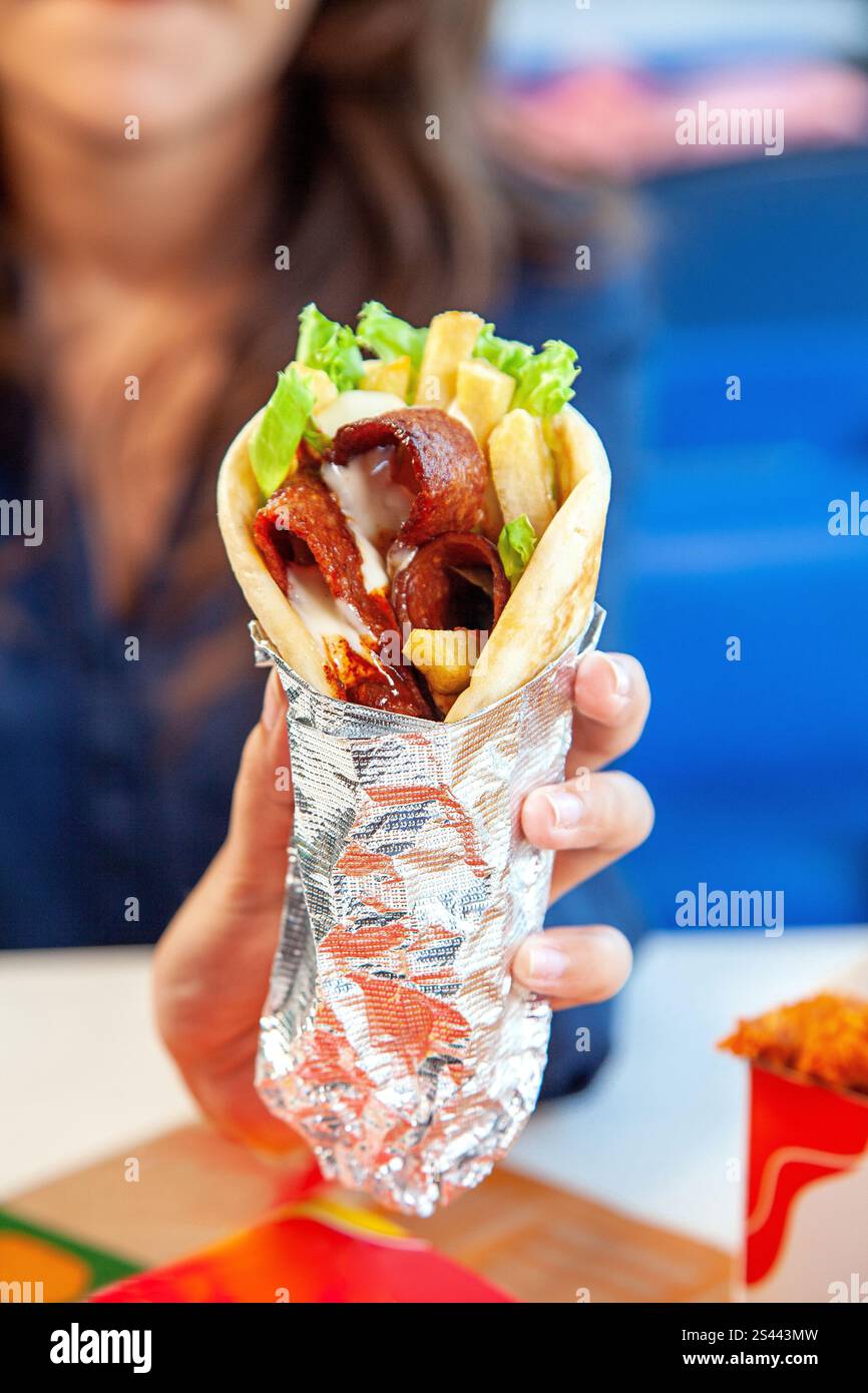 Prime beef thinly sliced doner wrap in pita bread holding in female ...