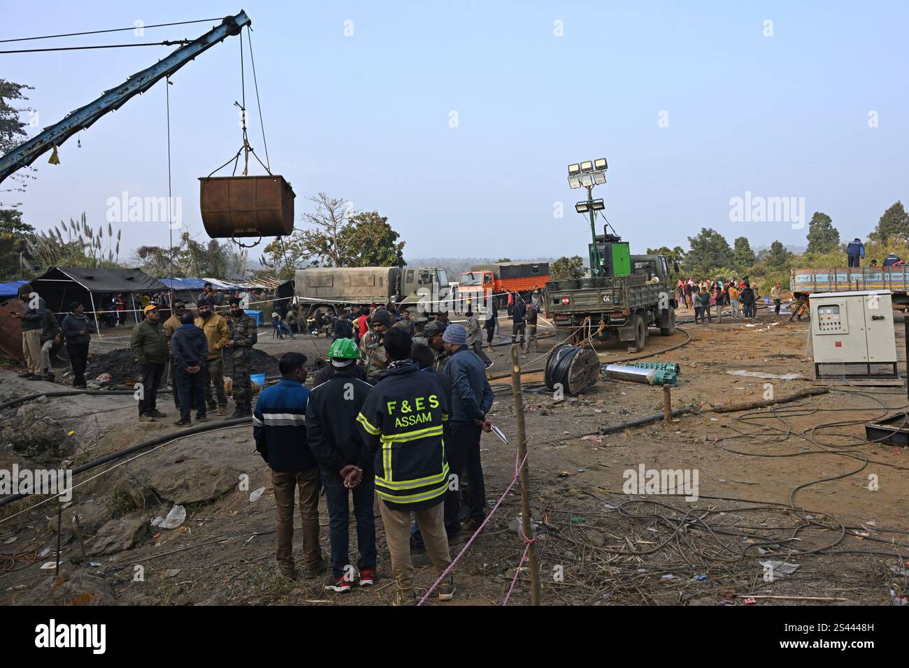 Rescue workers and others stand near a coal mine where at least nine ...