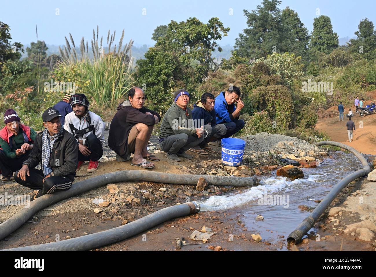 Locals wait near a coal mine where at least nine miners became trapped ...
