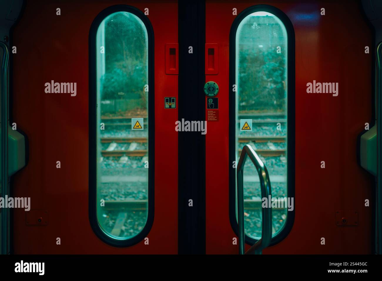 Bright red train doors with vertical windows revealing blurred railway ...