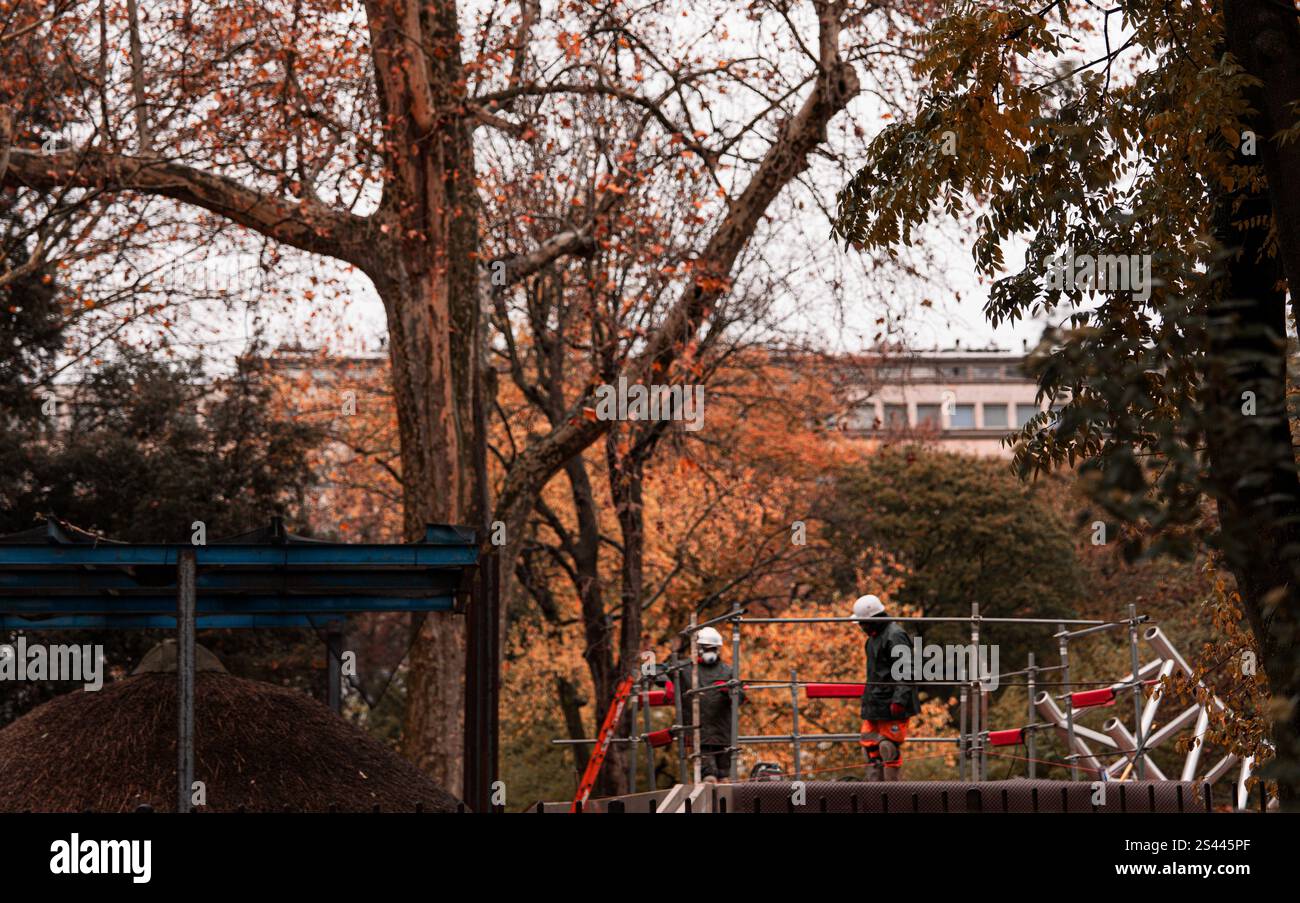 Construction workers maintaining a park during autumn in a city ...