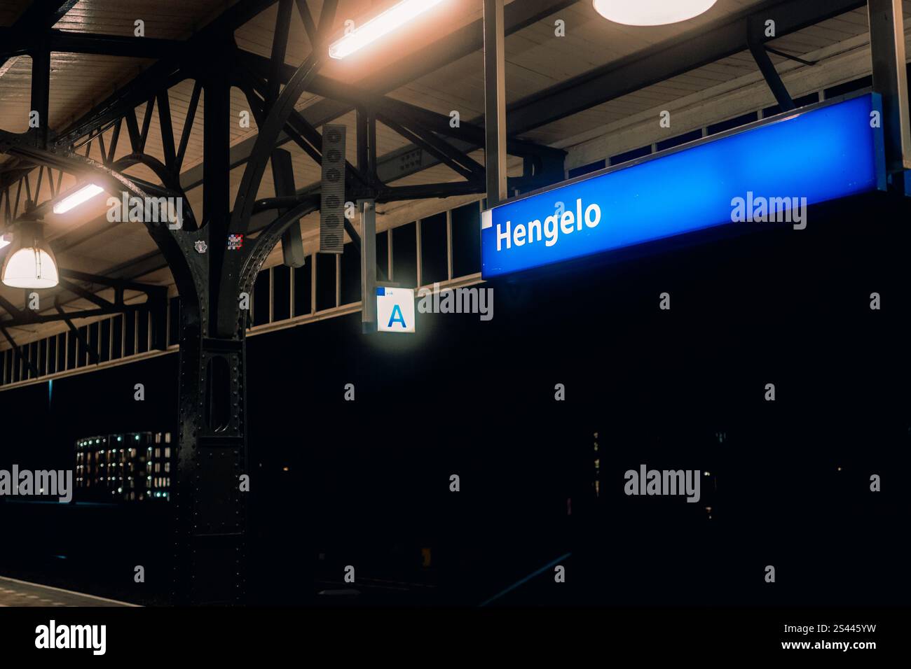 Night view of Hengelo train station with illuminated blue signage ...