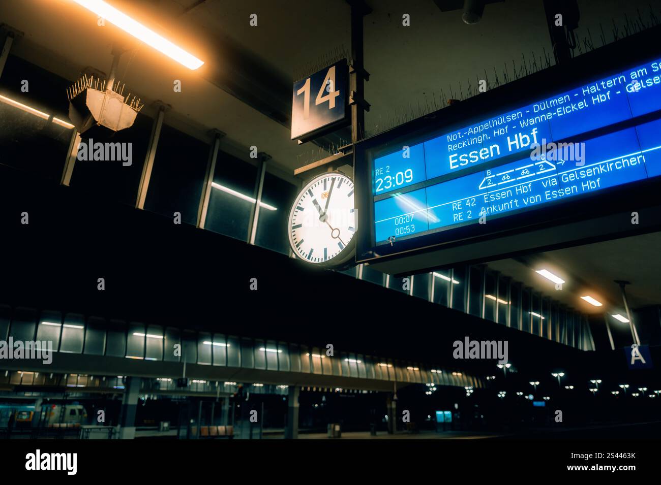 Night view of Münster train station platform with illuminated timetable ...