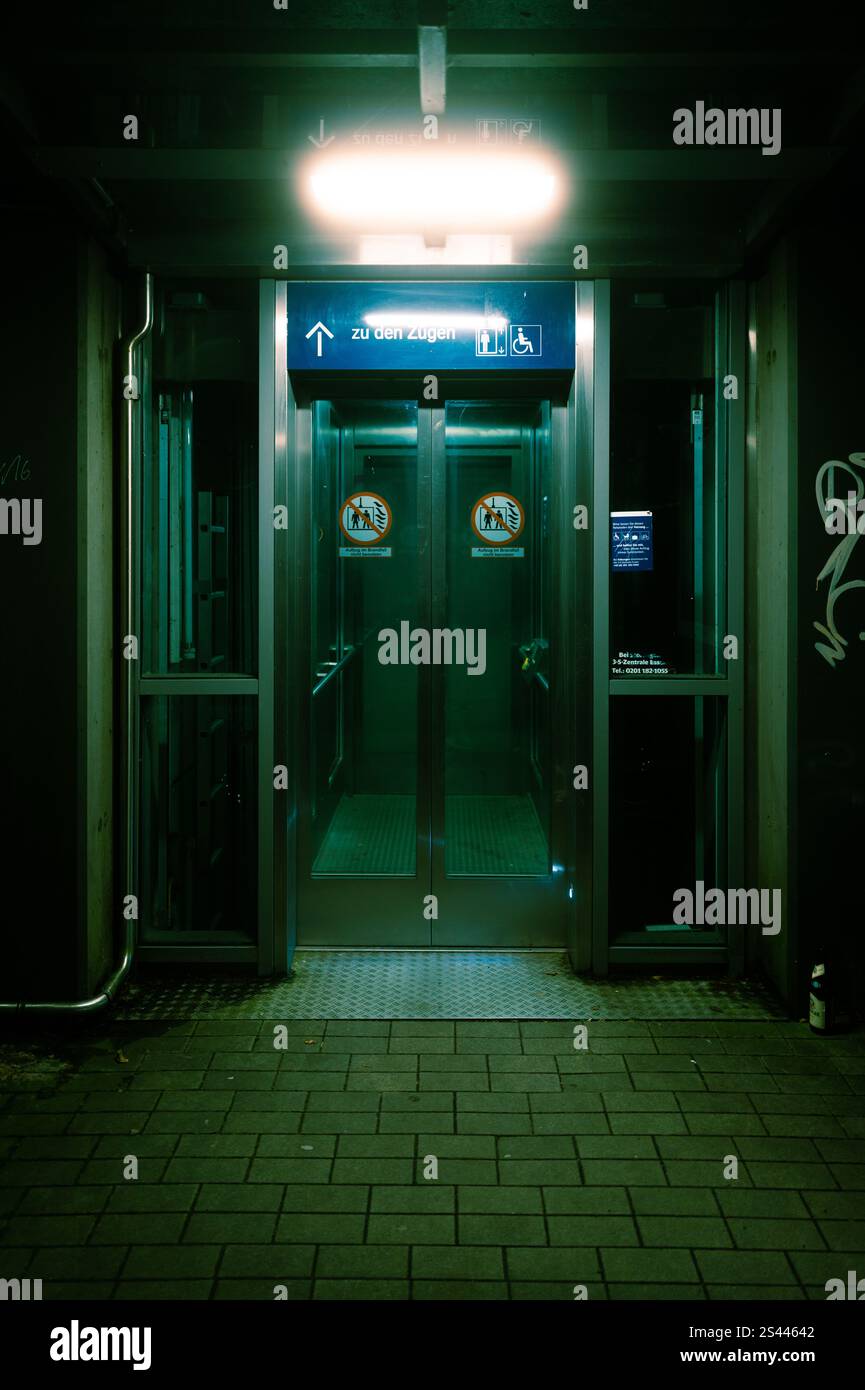 Urban night scene of a modern elevator entrance illuminated by green ...