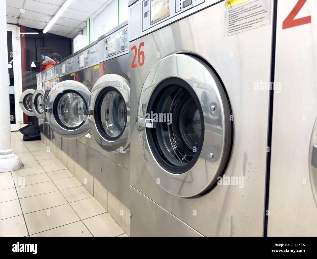 Modern laundry facility with multiple washing machines ready for use in ...