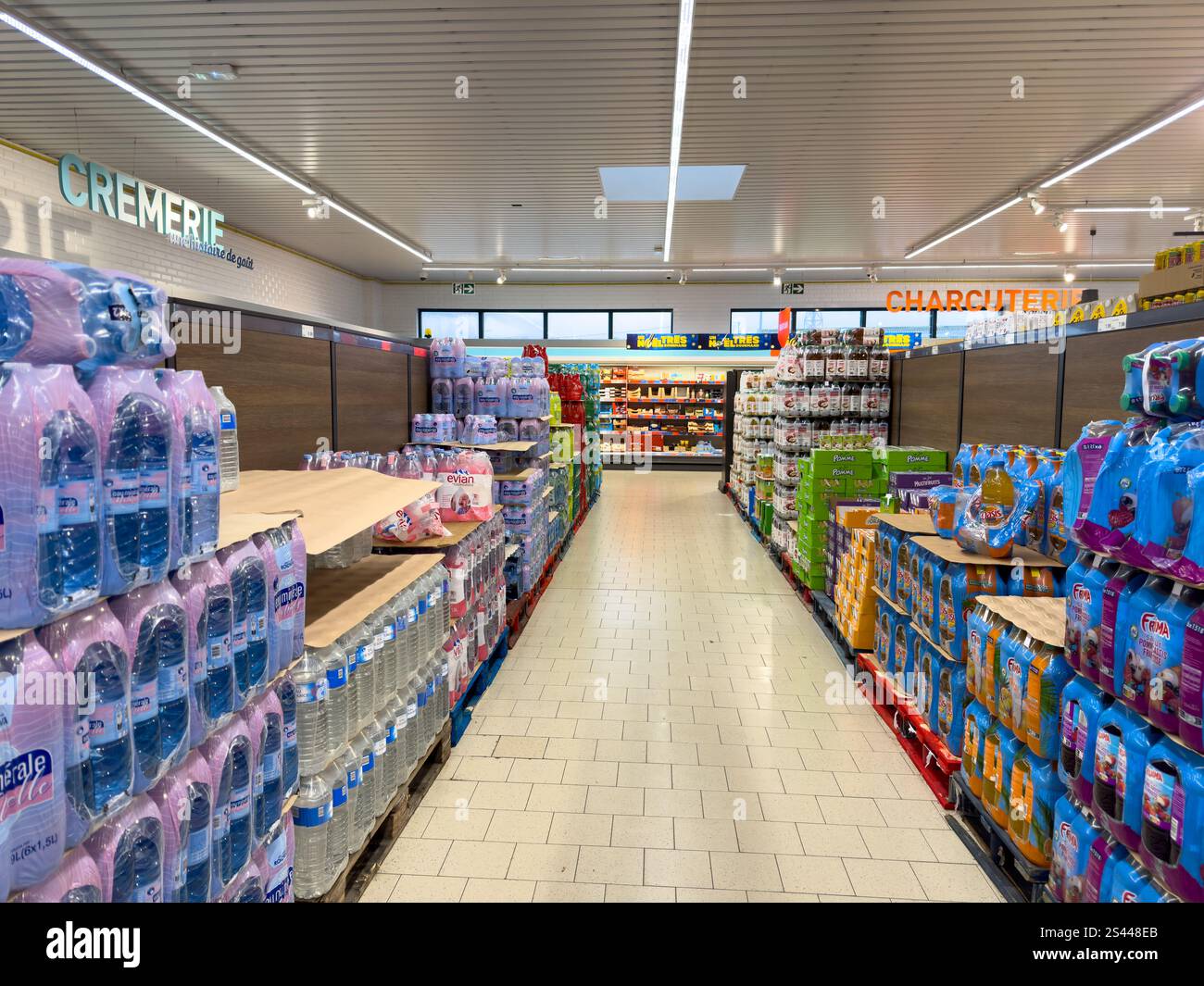 Aisle filled with various grocery products in a well-lit supermarket ...