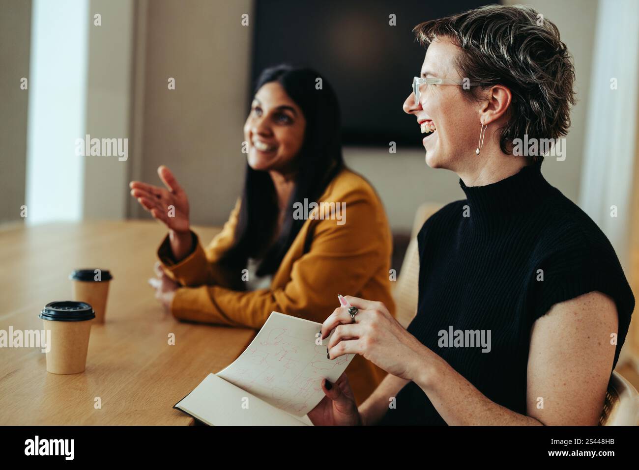 A casual meeting between colleagues in an office setting, featuring two ...