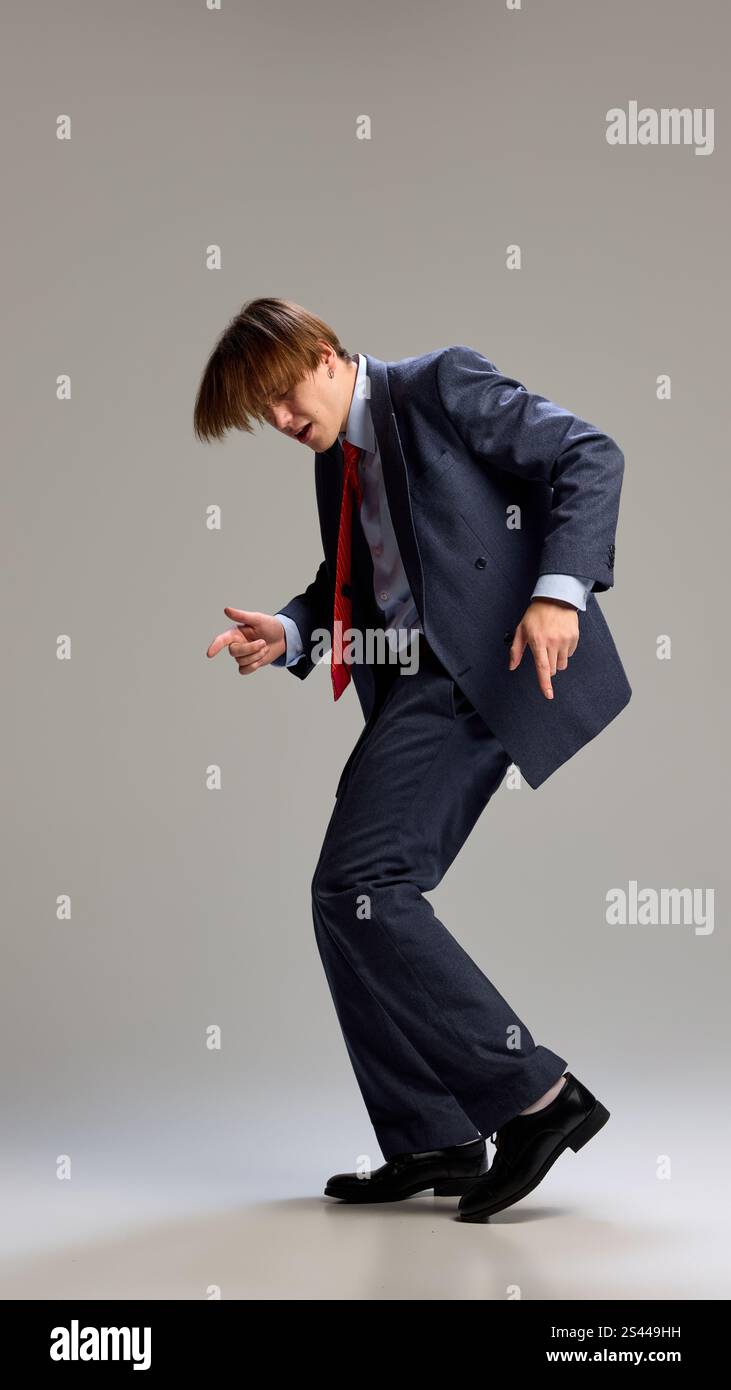 Dynamic photo of young man dressed formalwear and red tie, dancing with ...