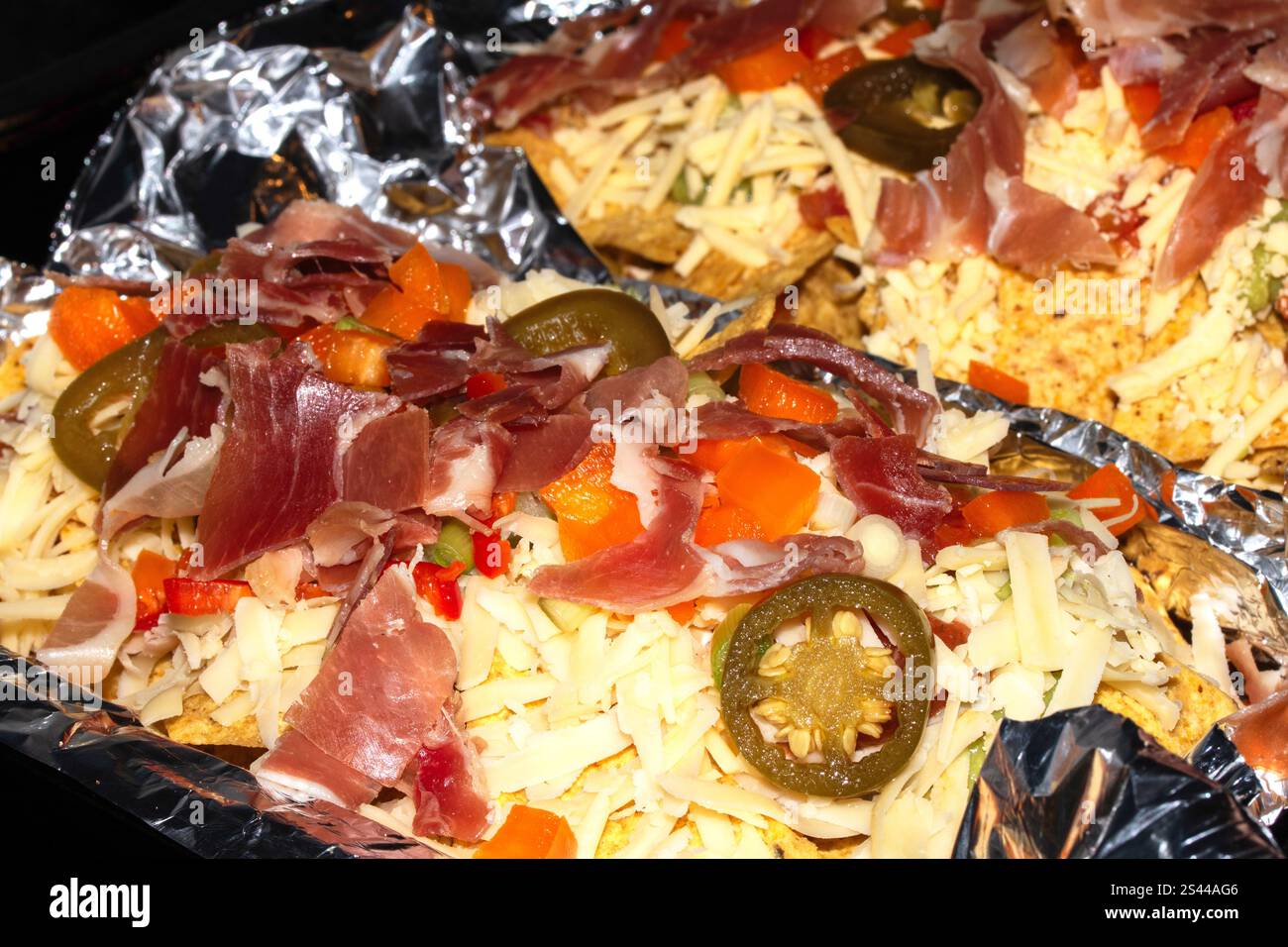 Loaded Nachos before being Cooked with Ham Cheese Jalapenos and Peppers ...