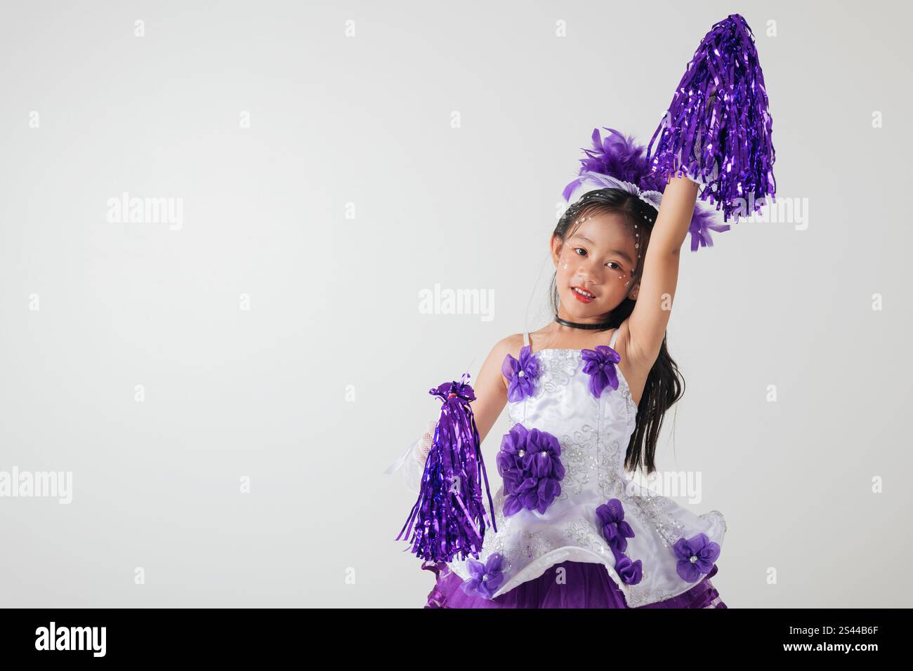 Portrait of a cheerful cheerleader girl in a purple and white outfit ...