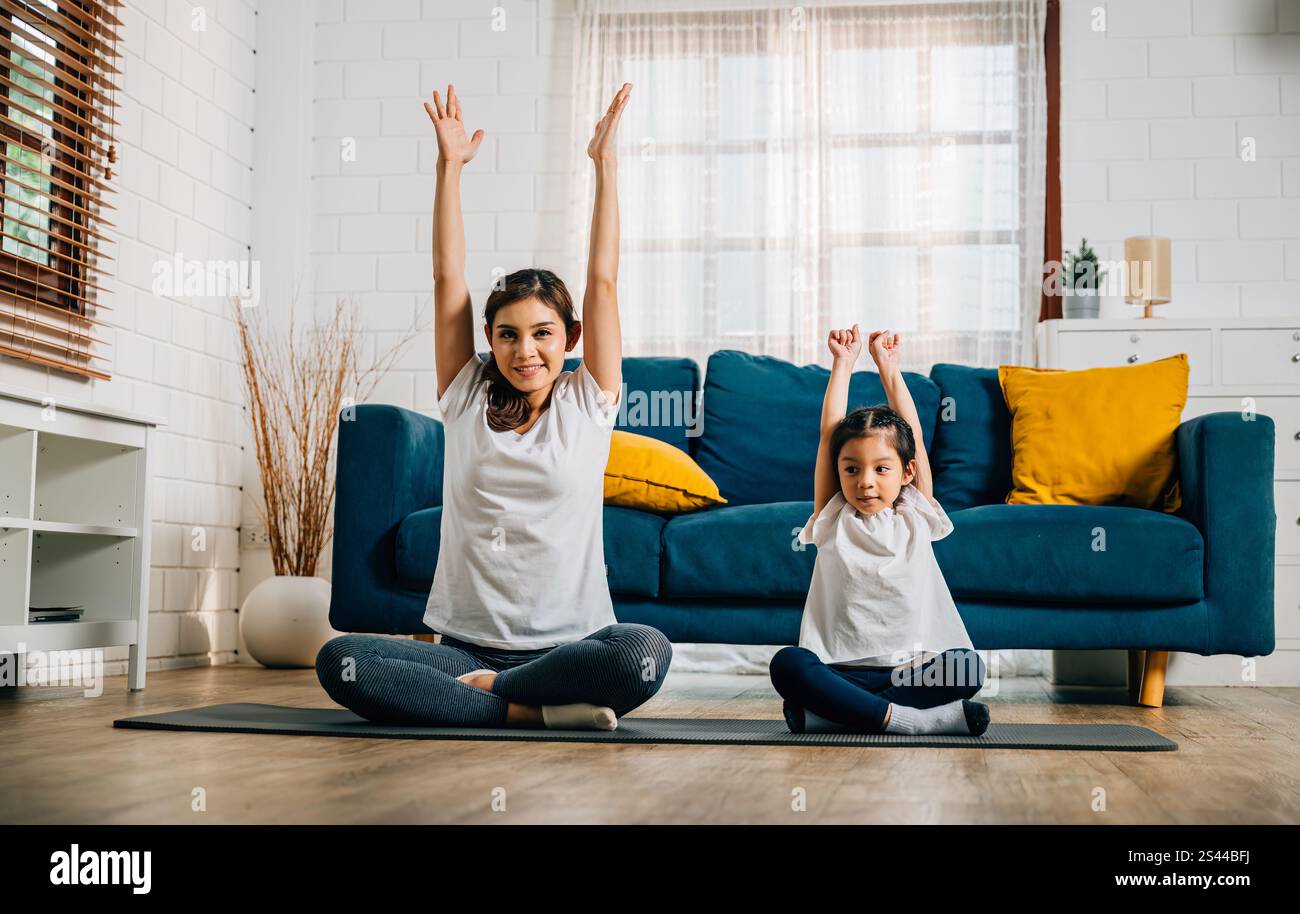 A mother teaches her daughter yoga focusing on stretch and balance in their home Stock Photo - Alamy