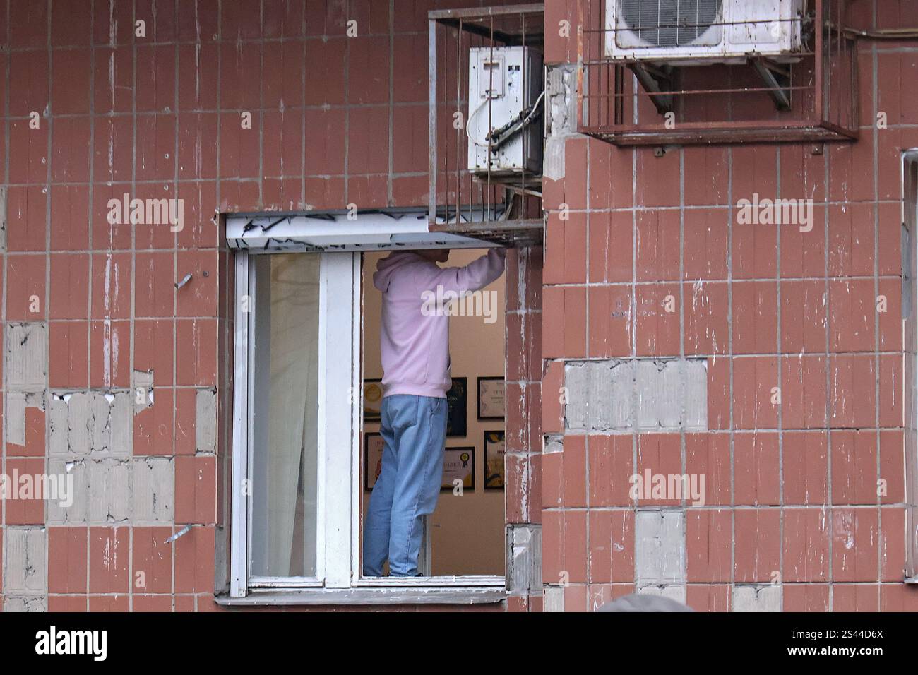 KYIV, UKRAINE - JANUARY 10, 2025 - A man examines a window broken by ...