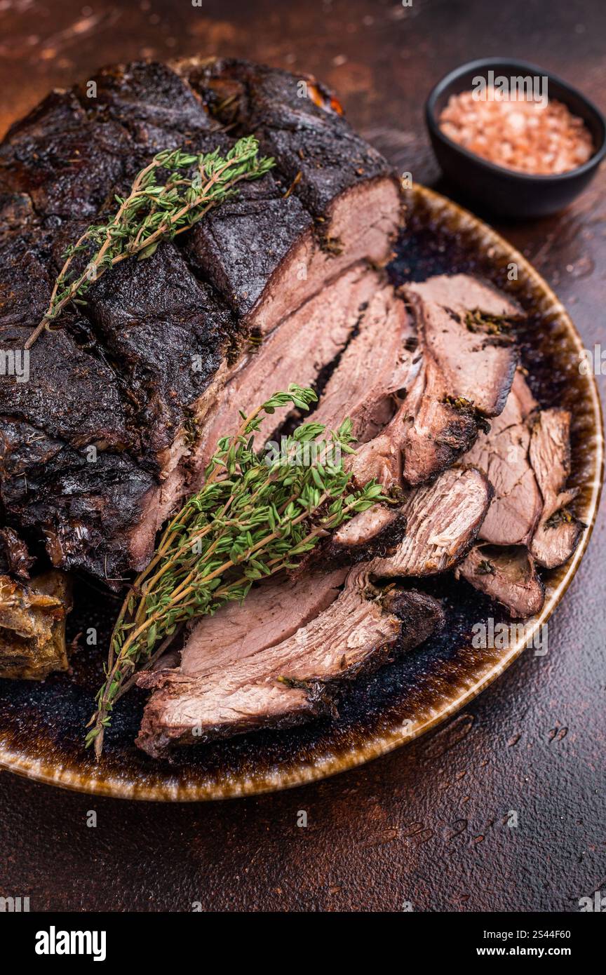 Baked and sliced Venison leg. roast meat of deer with bone on a plate ...