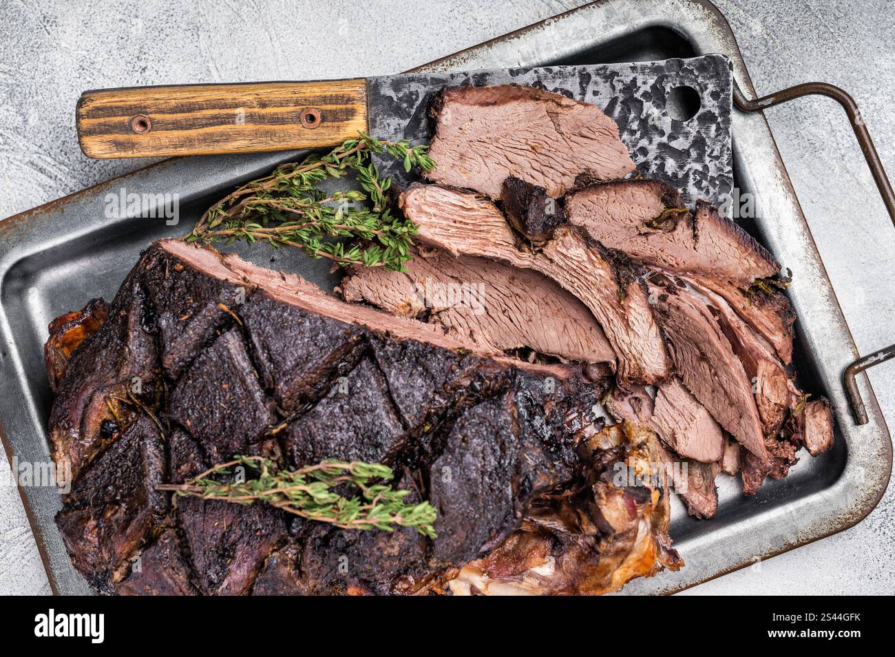 Roasted game meat of Venison, baked leg of roe deer on a tray with ...