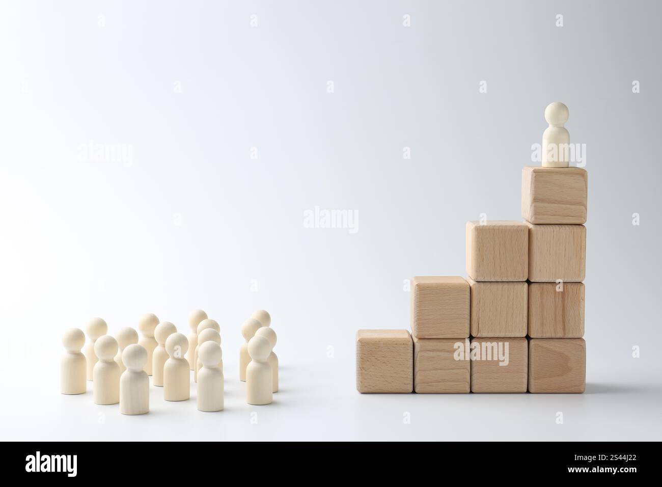 Human figures in front of stacked wooden blocks with one figure on top ...