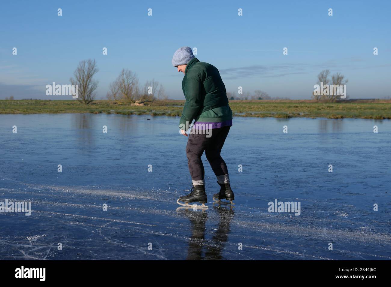 Jane Ison skates on a frozen flooded field in Upware, Cambridgeshire ...