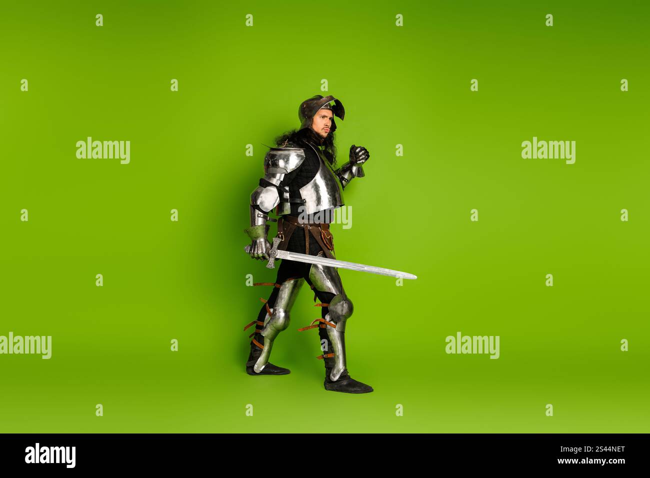 Knight in shining armor with a sword against bright green background ...