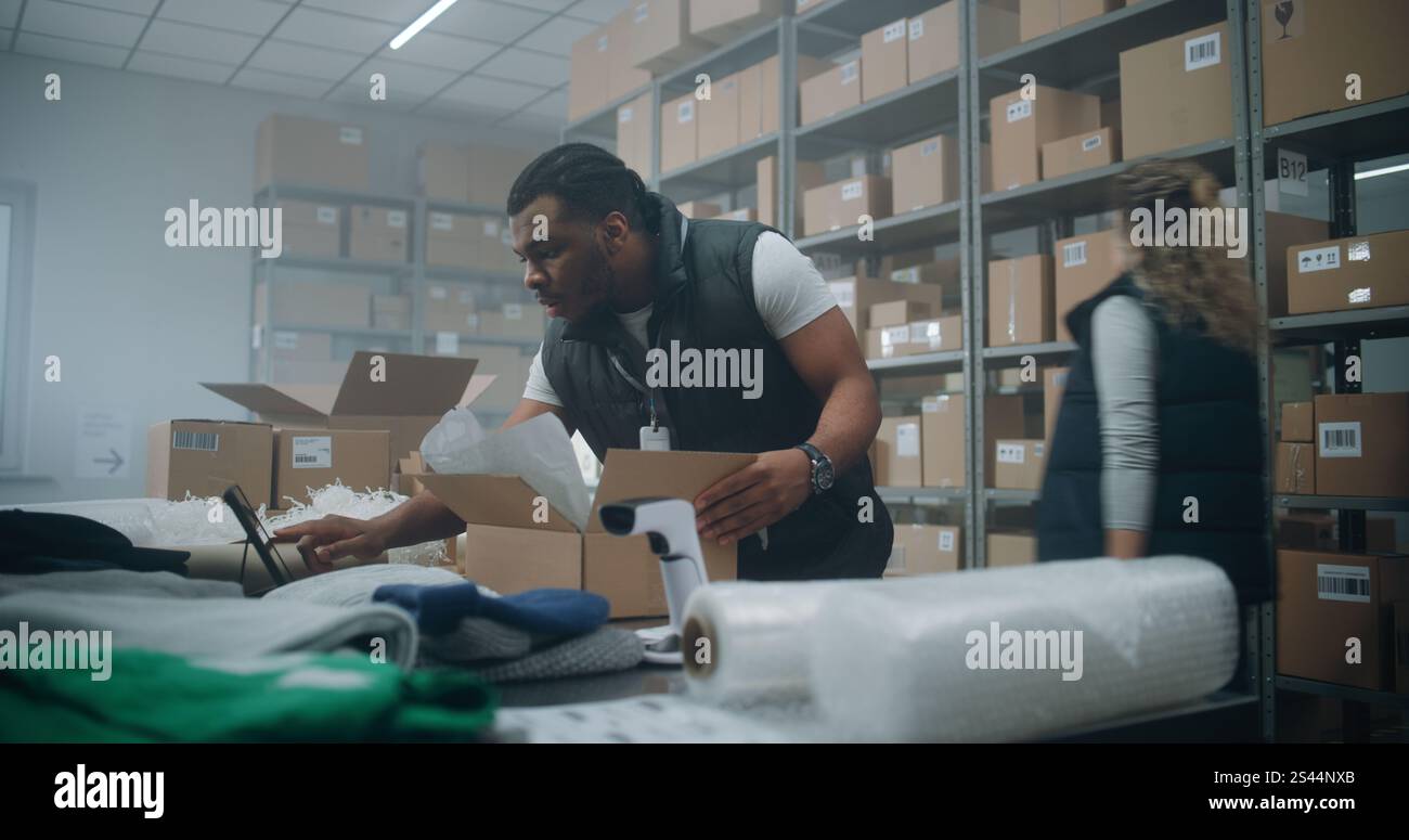 African American Warehouse Clerk Puts Sticker on Cardboard Box with ...