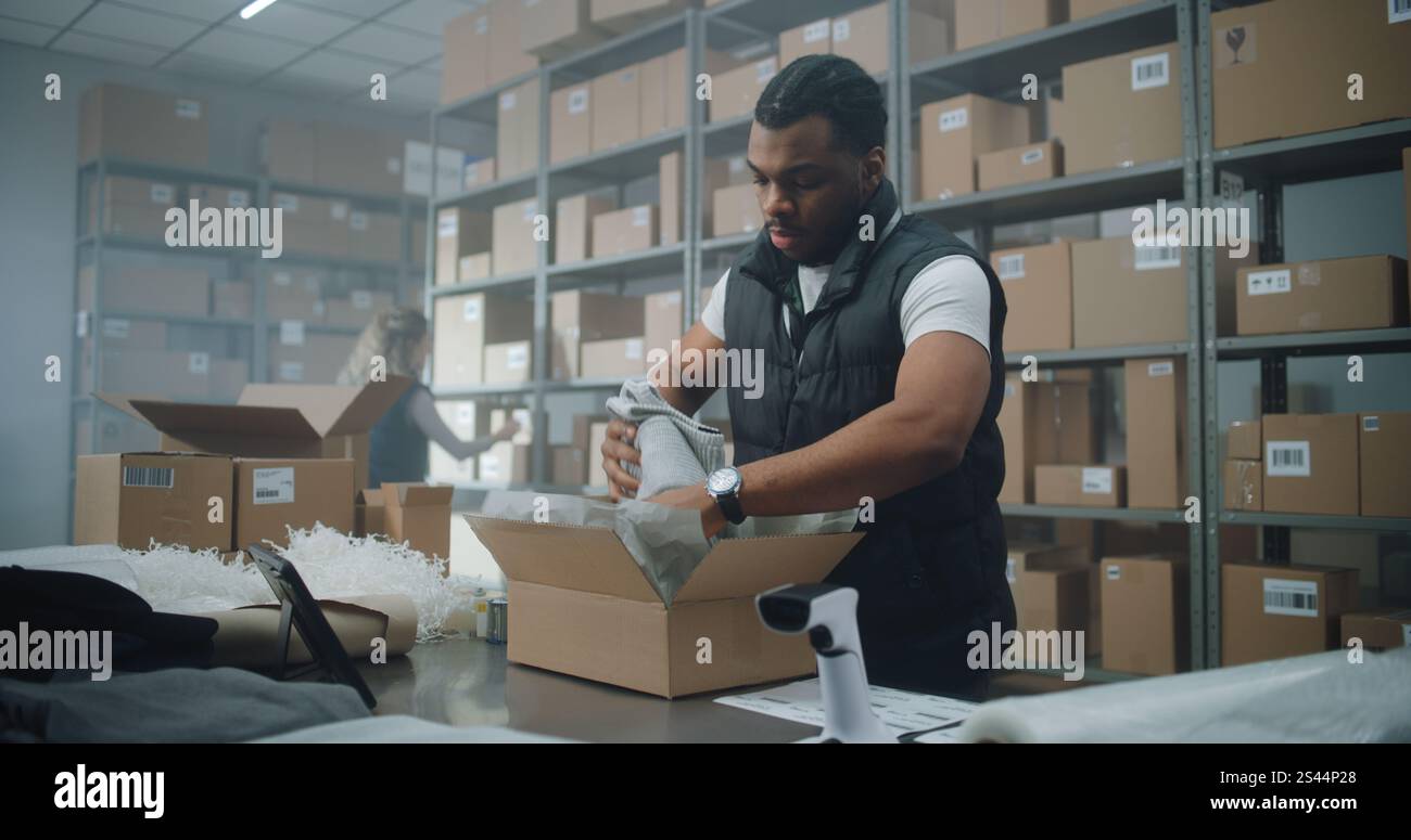 African American Warehouse Clerk, Postal Worker Packs Cardboard Box ...