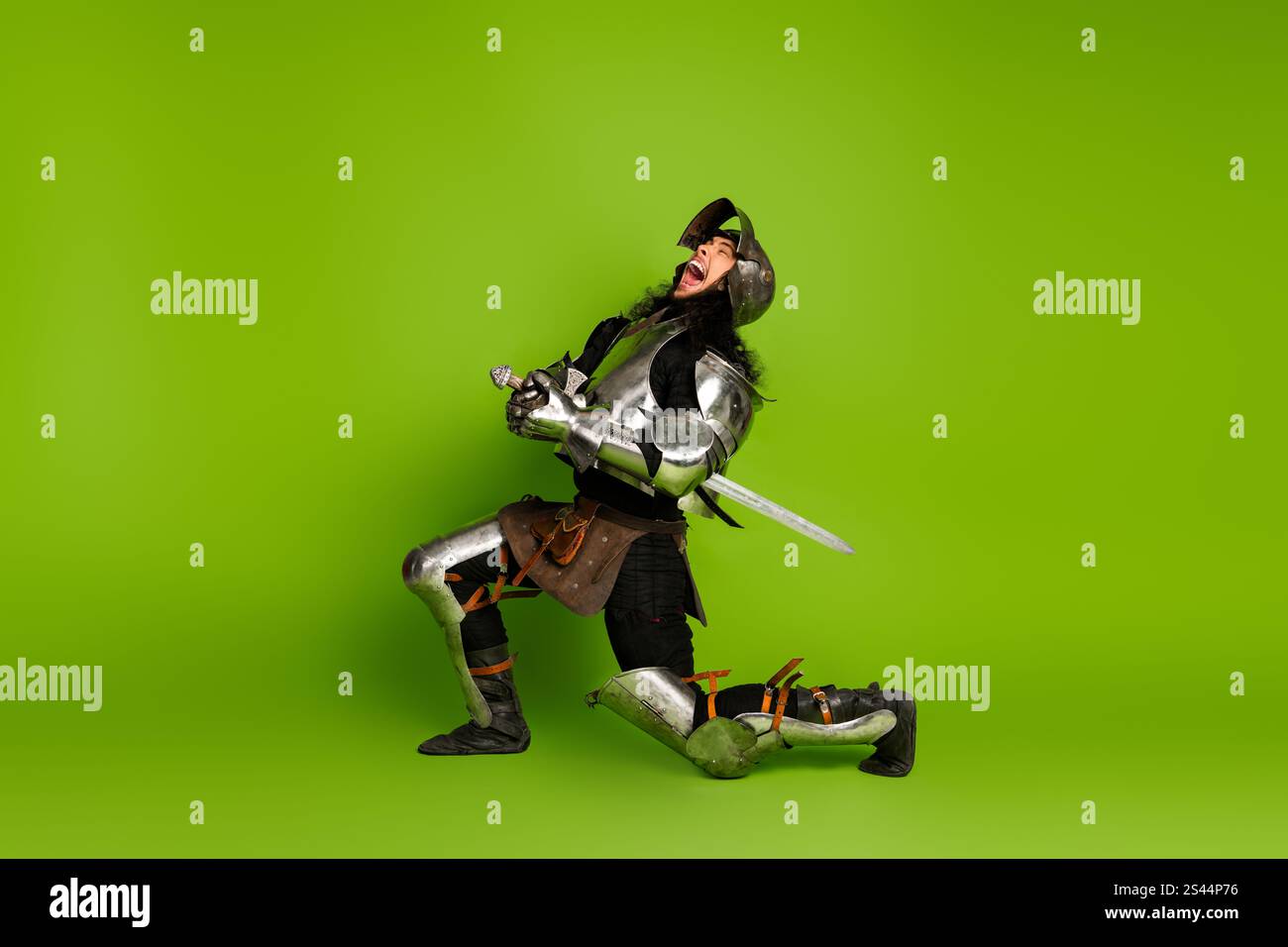 Medieval armored knight posing dramatically on green background holding ...
