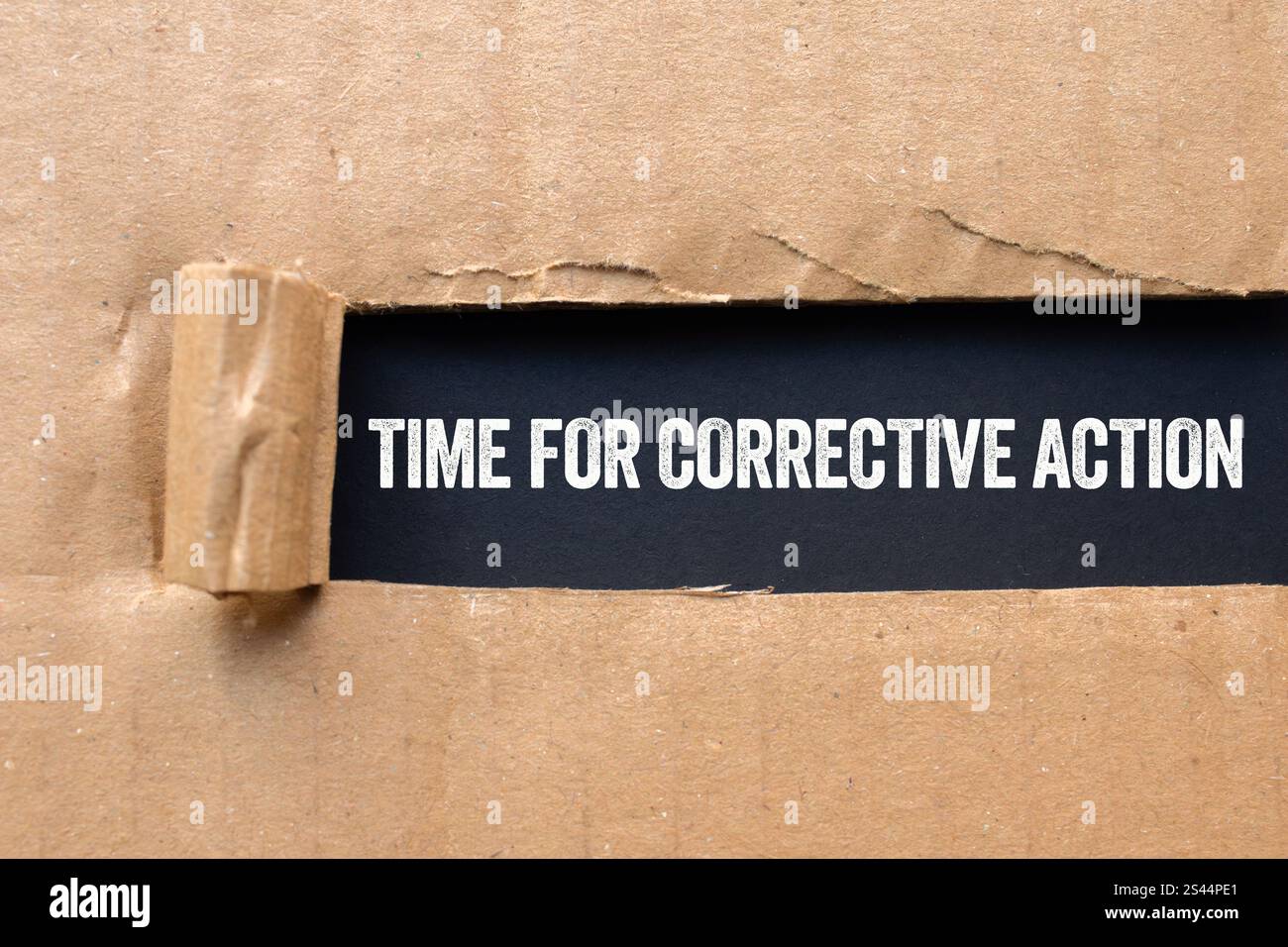 Time for corrective action message written on ripped torn cardboard paper on black background ...