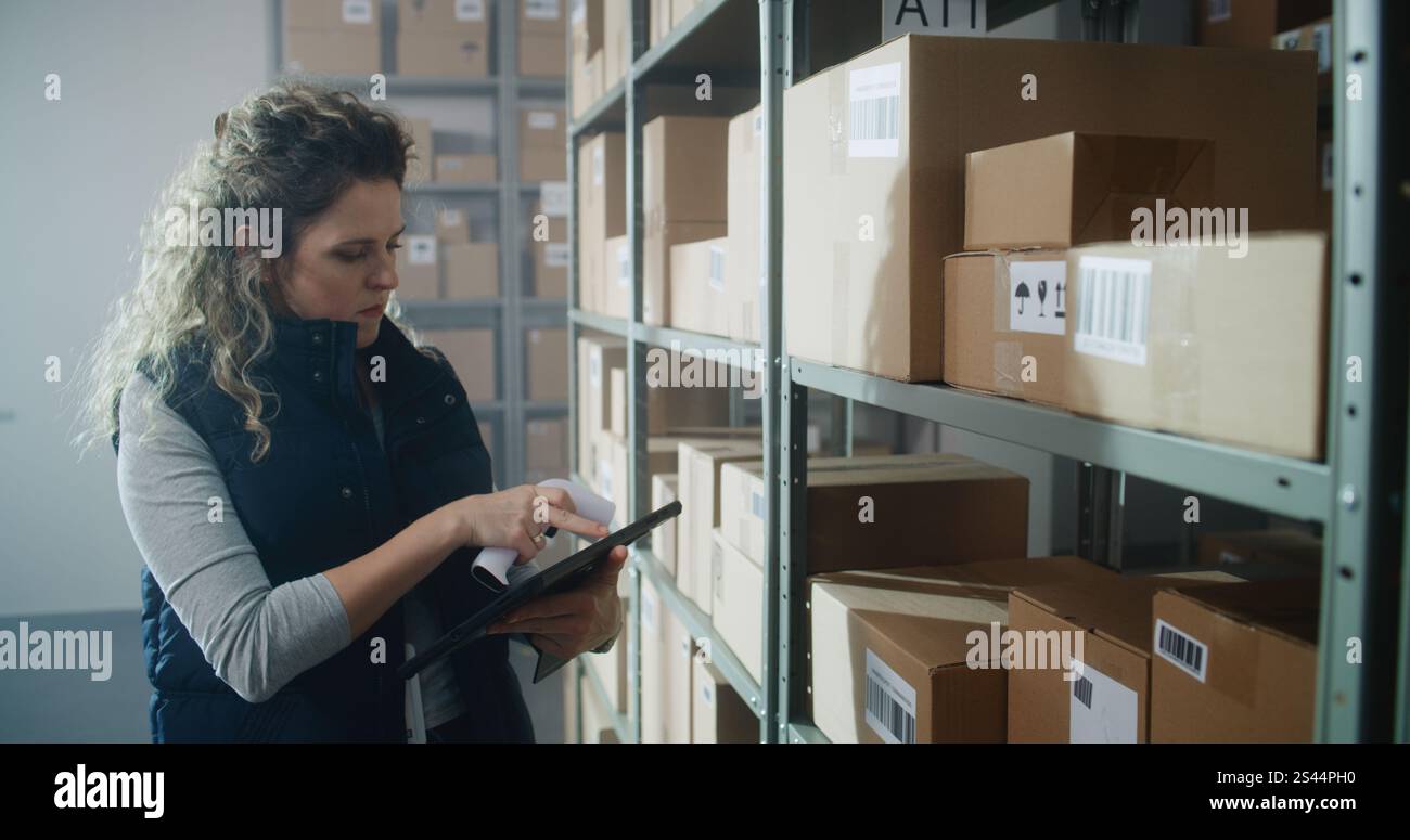 Female Warehouse Associate Scans Cardboard Box with E-Commerce Online Goods on Shelves with ...